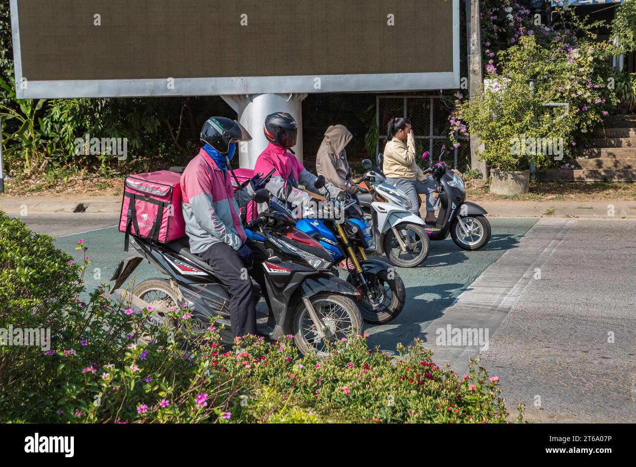 Food delivery drivers and other Thai motor scooter riders at a traffic ...