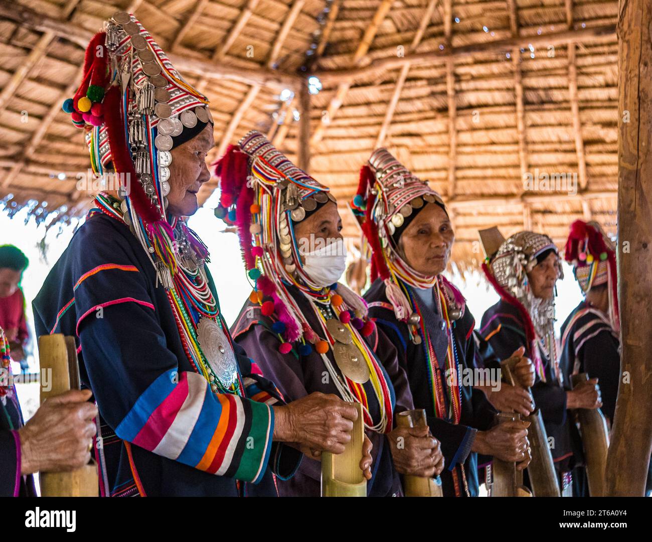 Elderly traditionally dressed people perform musical chant in the Akha ...