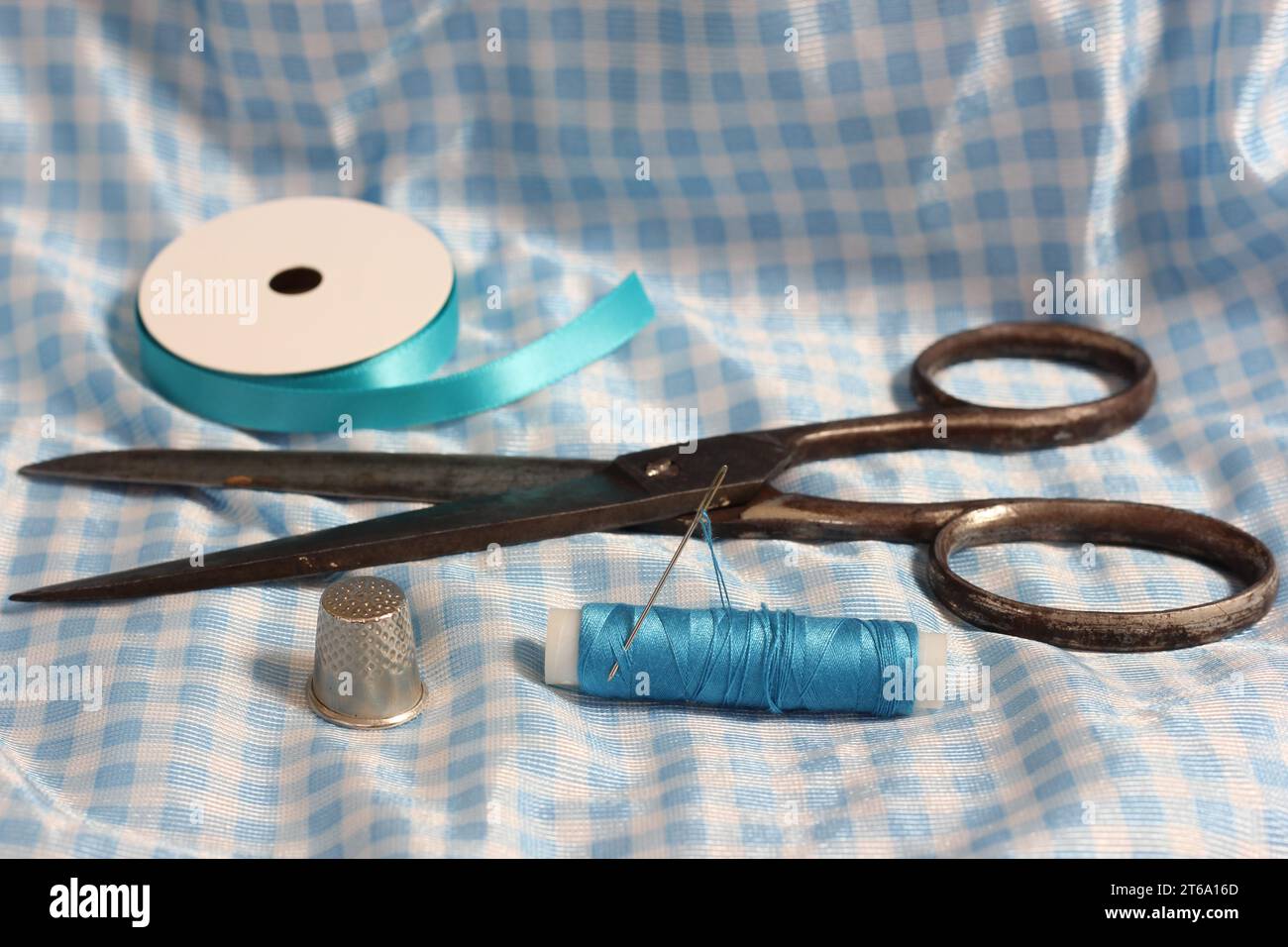 Spool of Blue Thread, Thimble and Needle on Vintage Blue and White ...