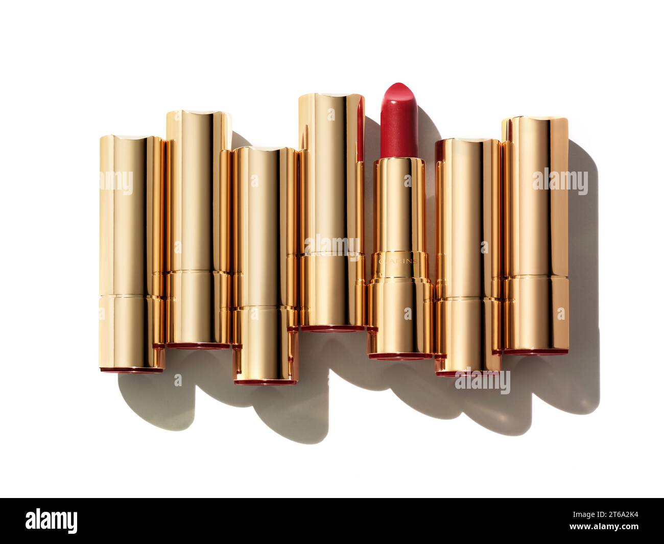 Seven lipsticks composition isolated on white background. Pink red gold ...