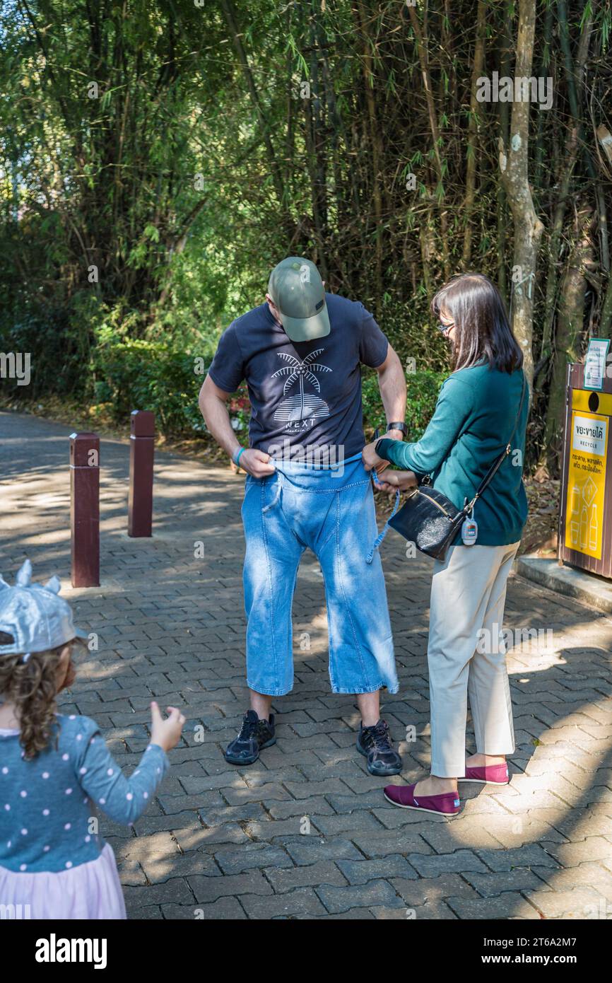 American tourist puts on denim pants provided to guests wearing short ...