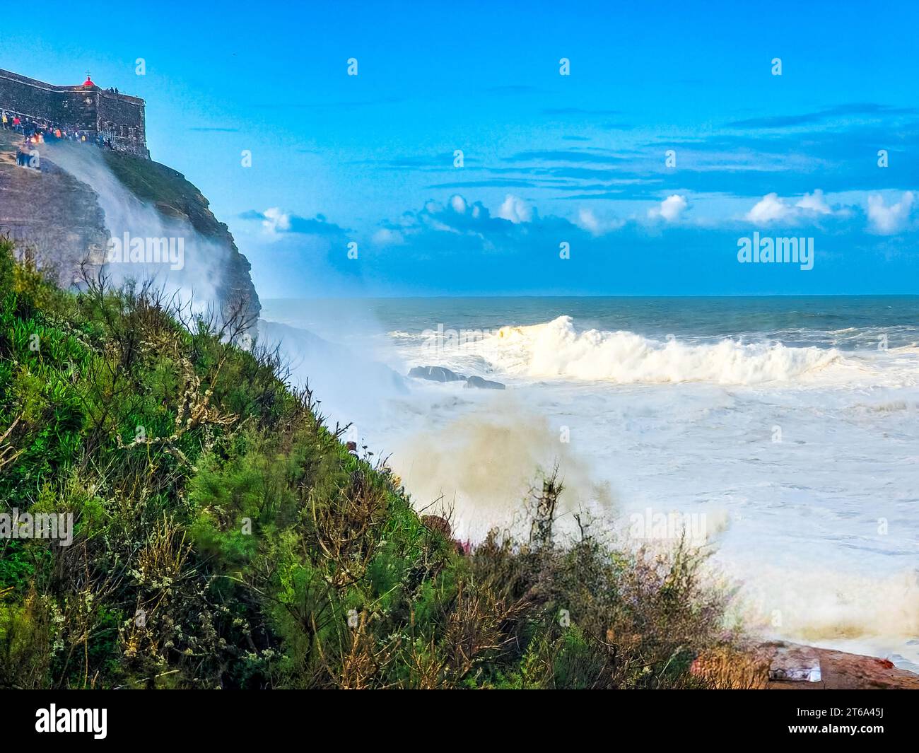 A powerful wave crashes against the rocky shore of a beach in Africa ...
