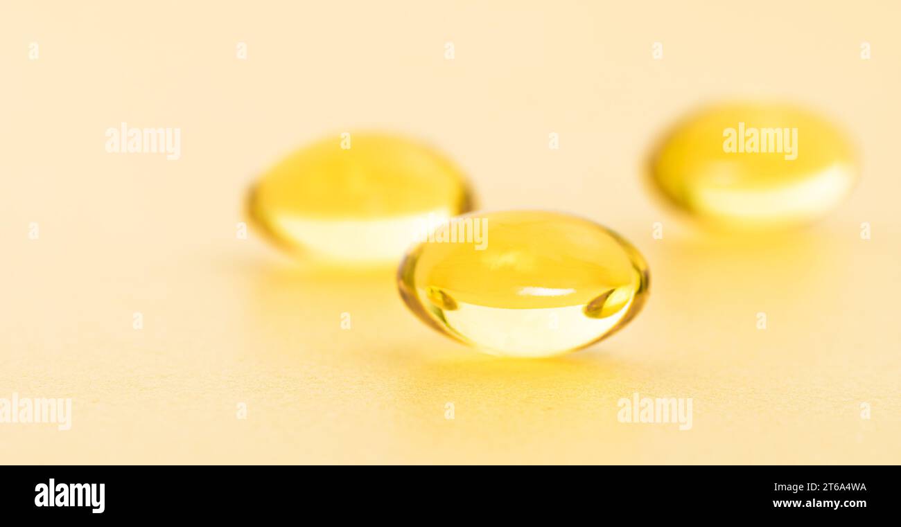 Fish oil supplement capsules on gold background. Cosmetics, omega 3 ...