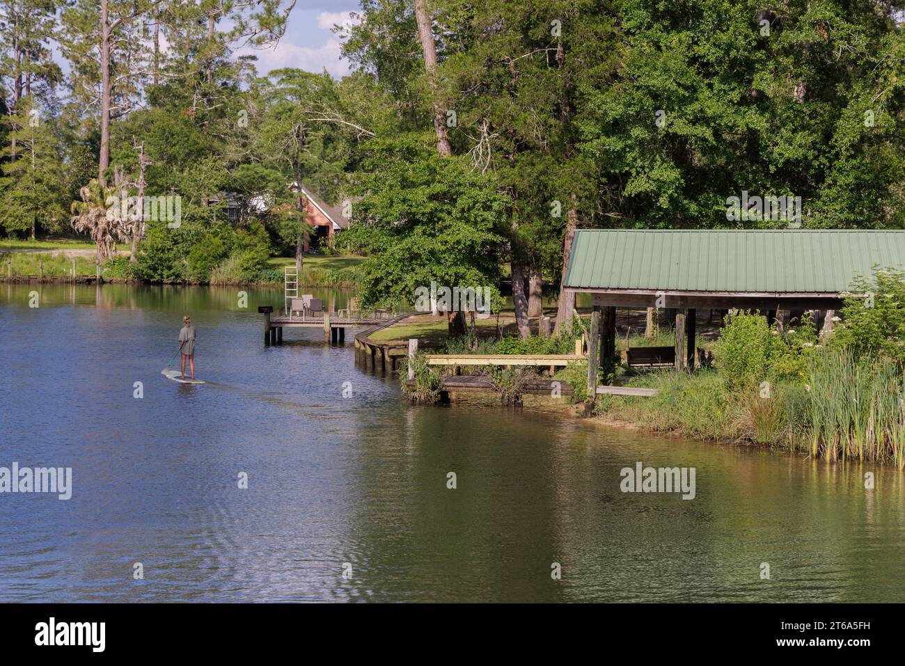 Young woman paddleboarding on the Magnolia River in Magnolia Springs ...