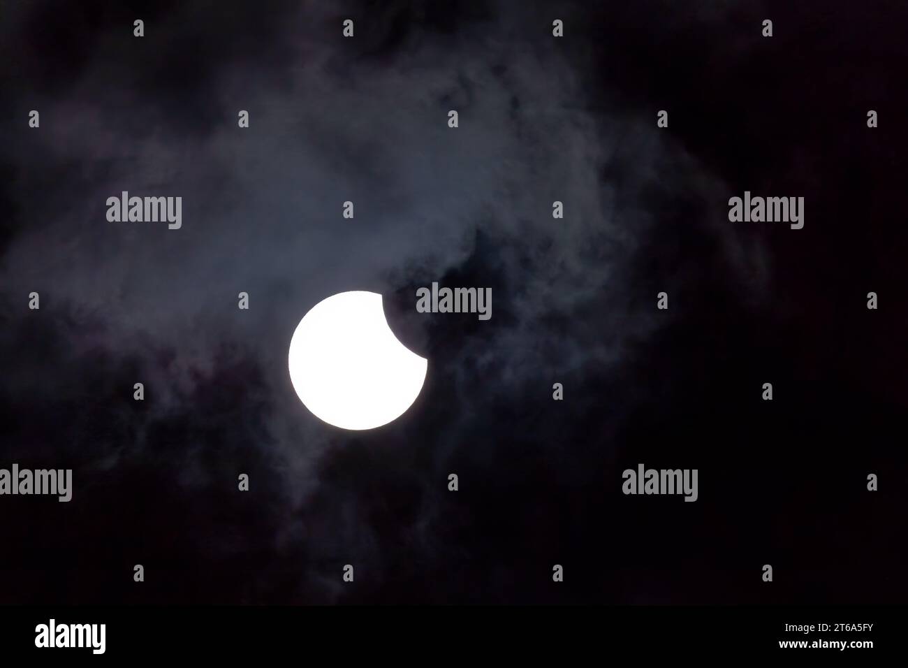 A tranquil nightscape with a full moon shining through wispy clouds in ...