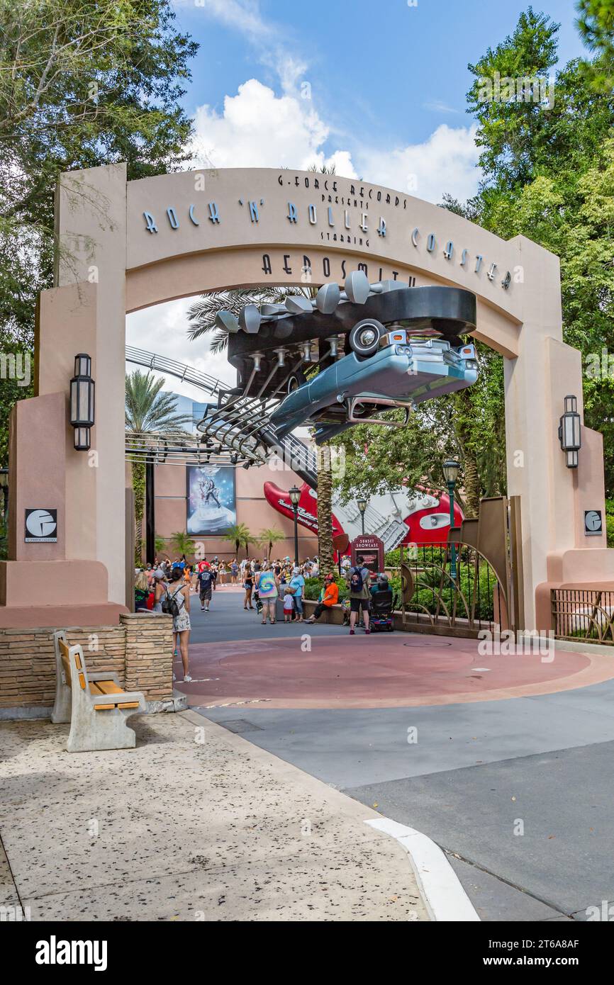 Masked park guests exiting under the entrance sign for the Rock 'n ...