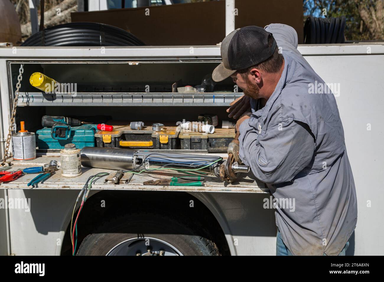 Man prepares a submersible pump for a residential water well Stock ...