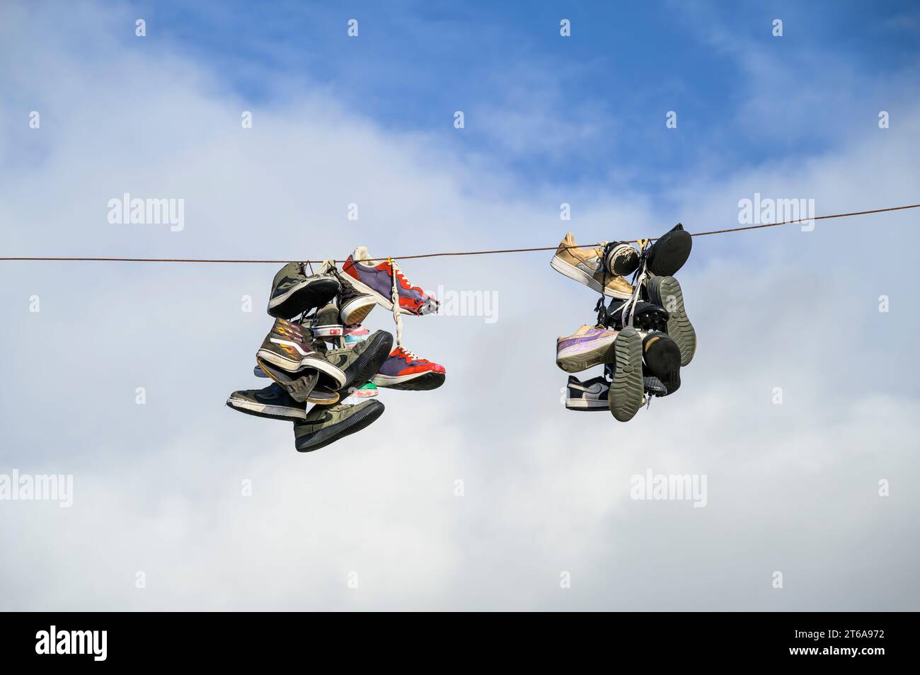 Sports shoes hanging from an overhead wire Stock Photo - Alamy