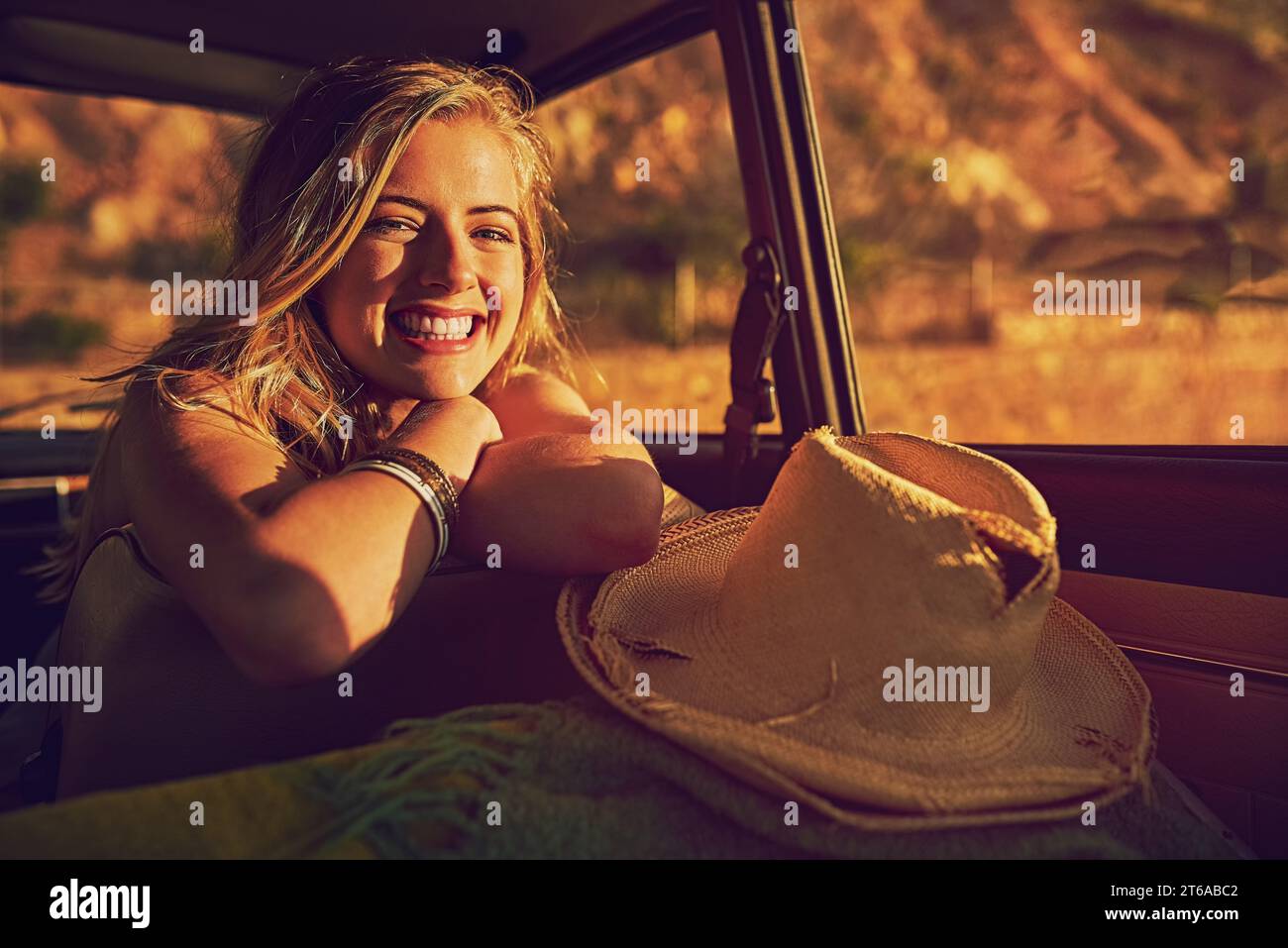 On the road again. Portrait of a happy young woman sitting inside a car ...