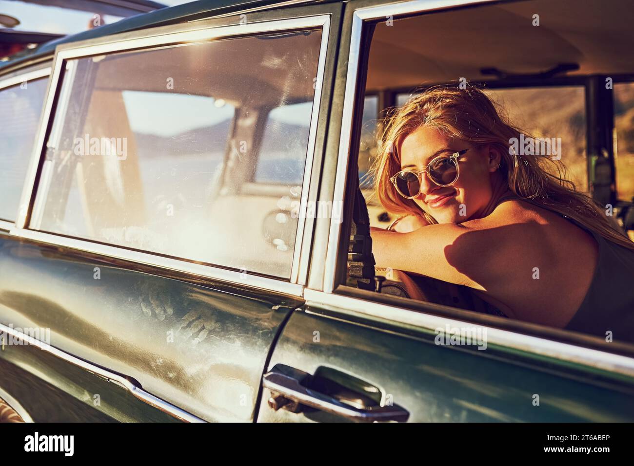 Shes a happy wanderer. Portrait of a happy young woman sitting inside a ...