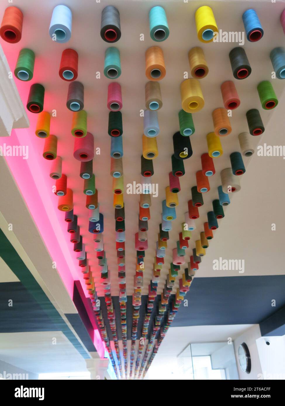 Abstract image of rows of spools of coloured threads in lines on the ...