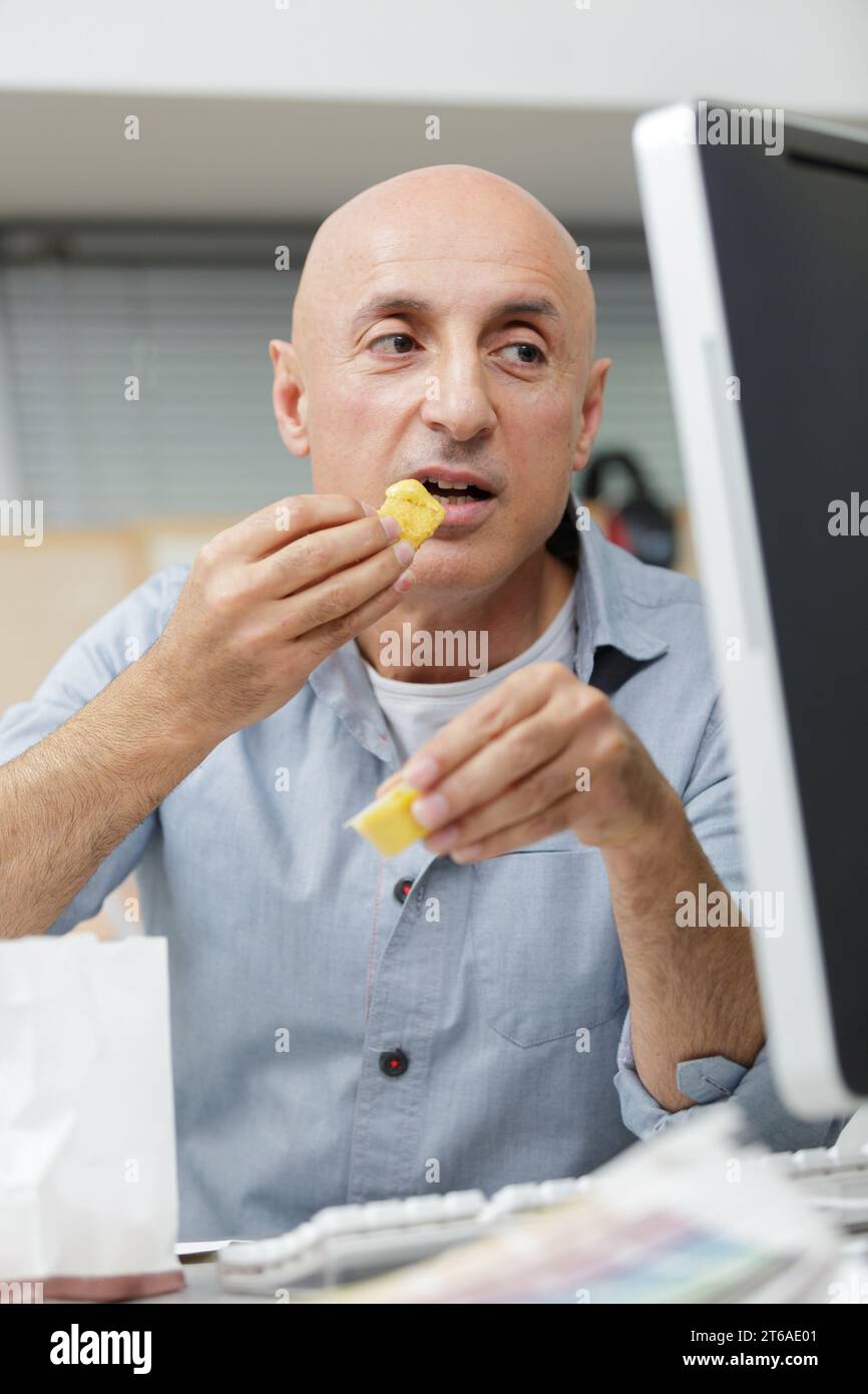 man eating chips in front of computer Stock Photo - Alamy