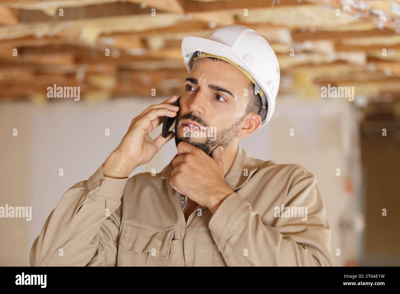 a concerned builder on telephone Stock Photo - Alamy