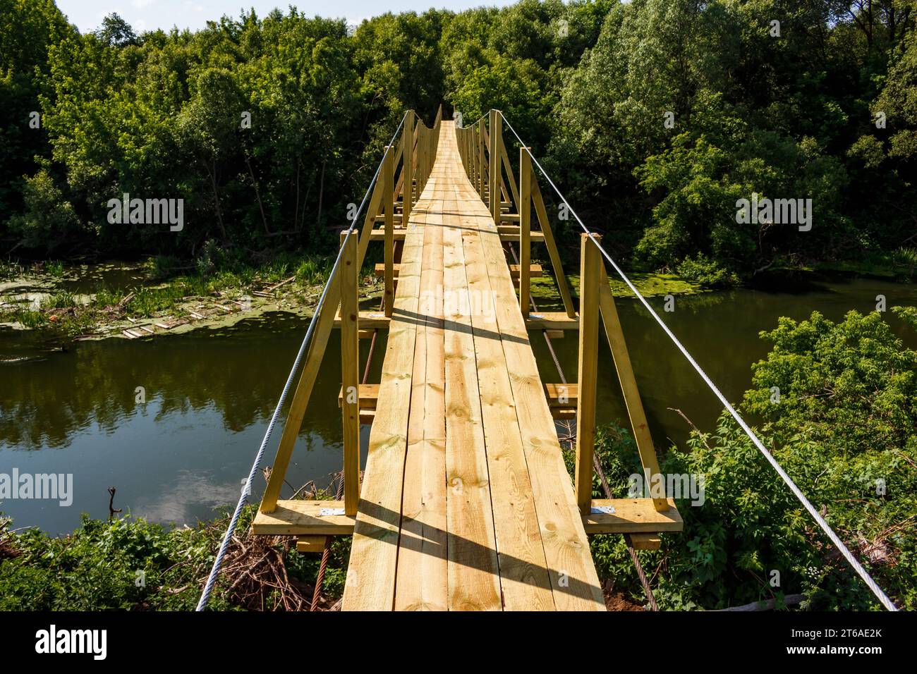 New wooden suspension bridge over the river for pedestrians in the ...