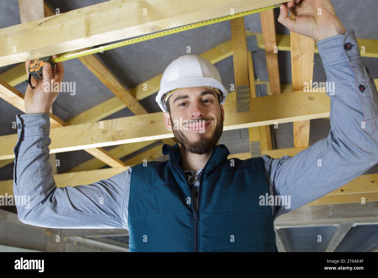 happy carpenter constructing and measuring wood house structure Stock ...