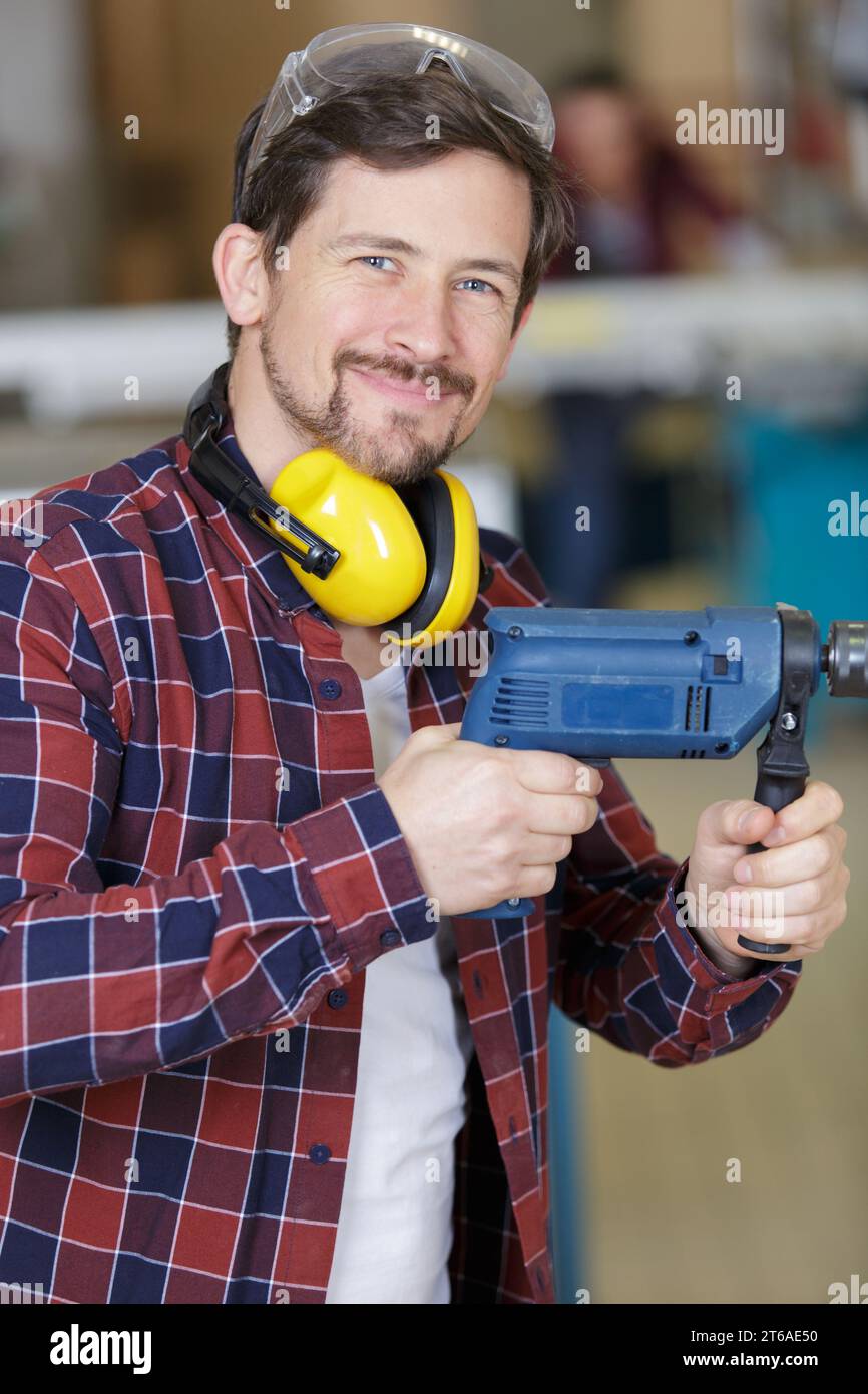 Smiling craftsman working drill hi-res stock photography and images - Alamy