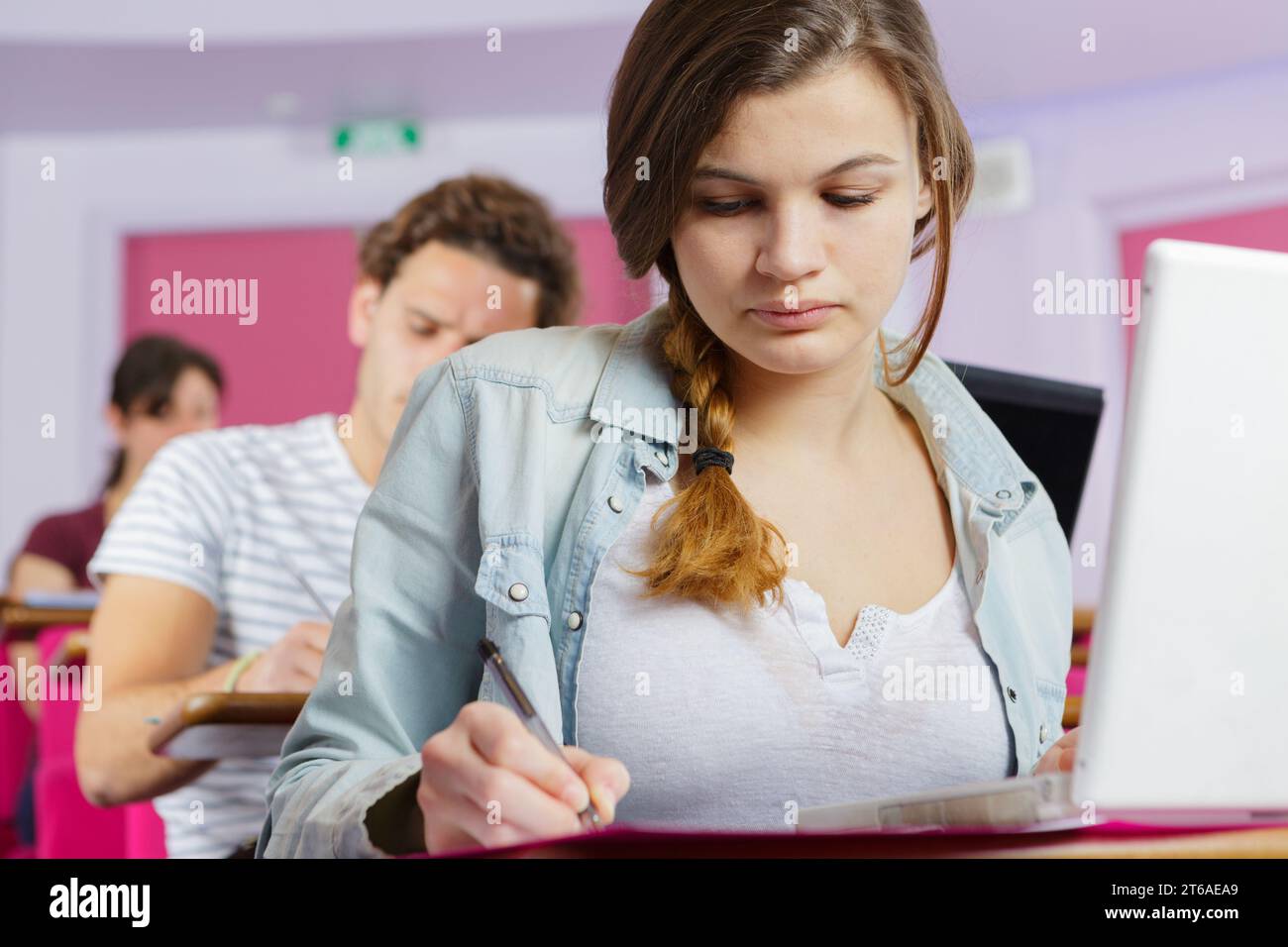 female student writing notes in class Stock Photo - Alamy