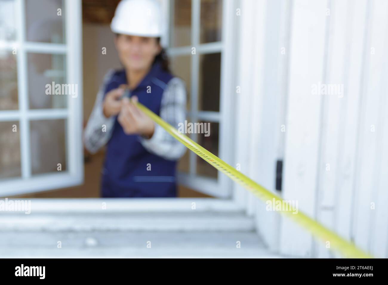 extended tape measure held by professional woman Stock Photo - Alamy