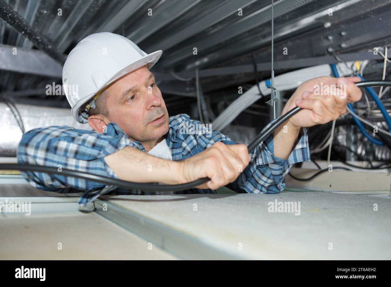 worker wiring cables on the ceiling Stock Photo - Alamy