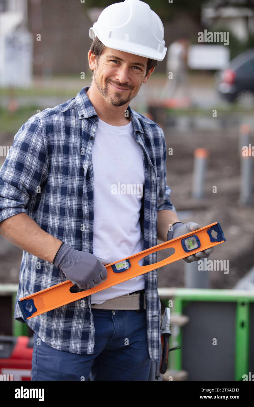 happy man checking level of wood at construction site Stock Photo - Alamy