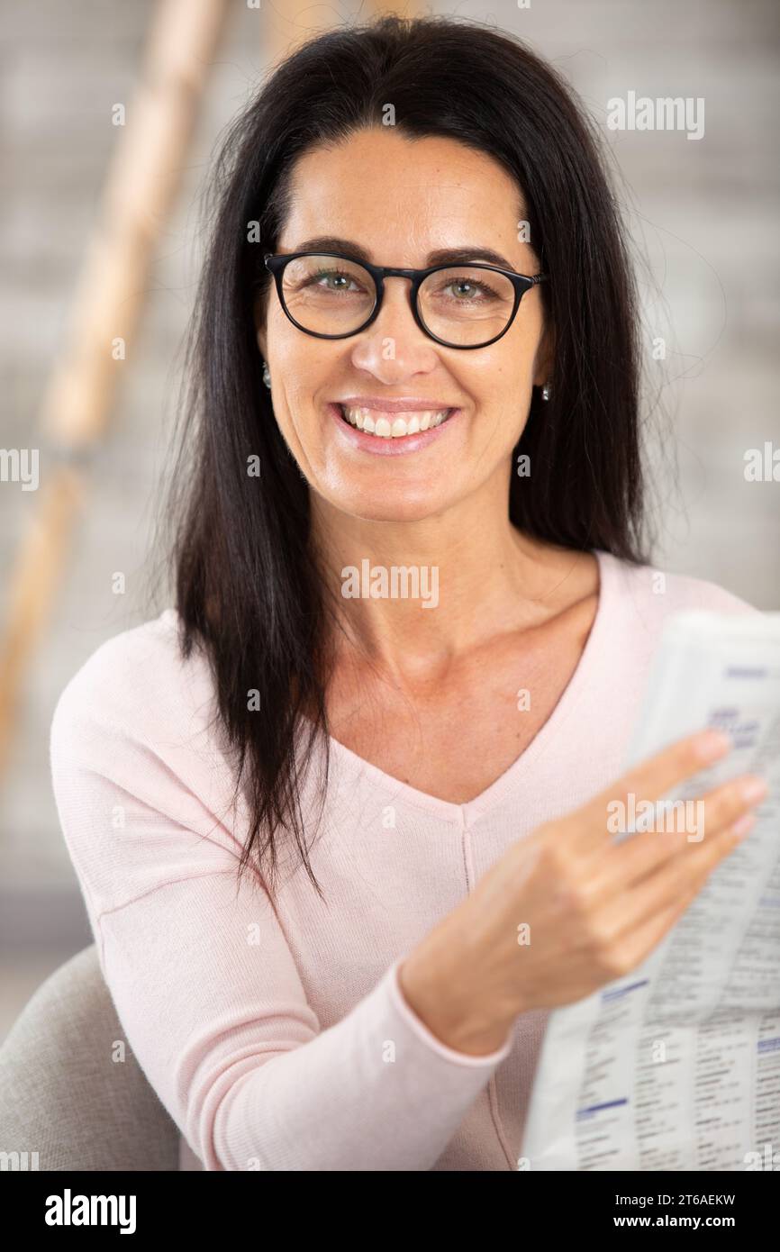 attractive middle-aged woman reading a newspaper Stock Photo - Alamy