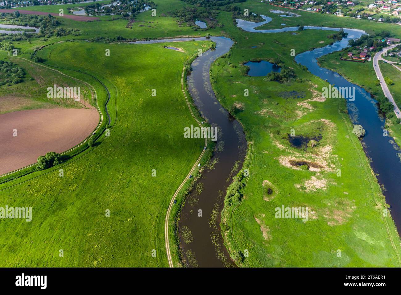 Landscape from the air, an elongated and winding river bed among green ...