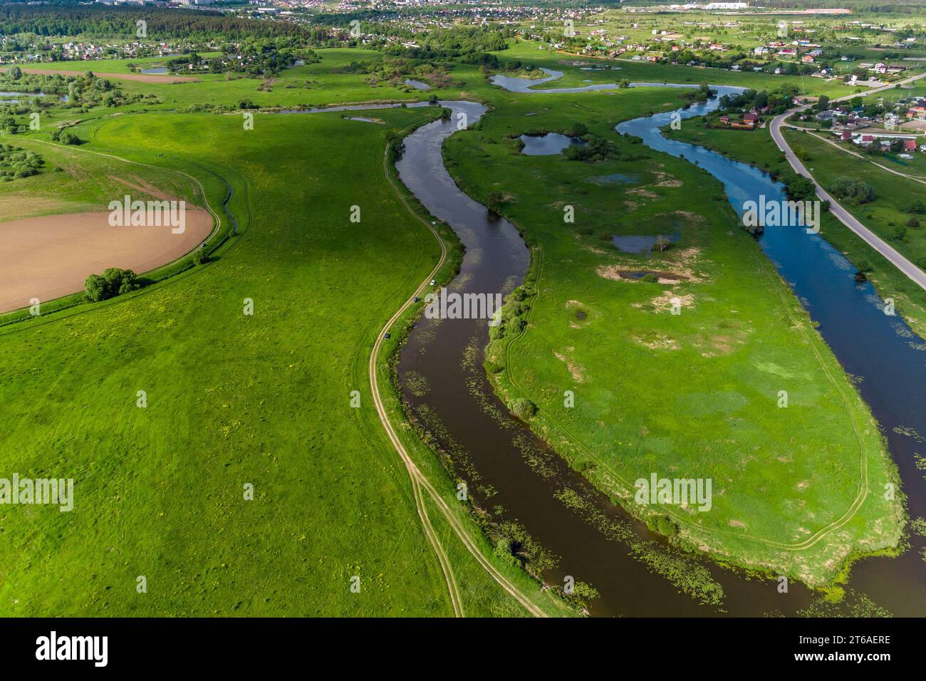 Landscape from the air, an elongated and winding river bed among green ...