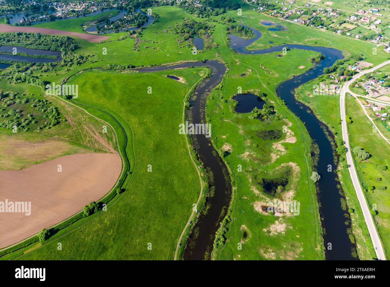 Landscape from the air, an elongated and winding river bed among green ...