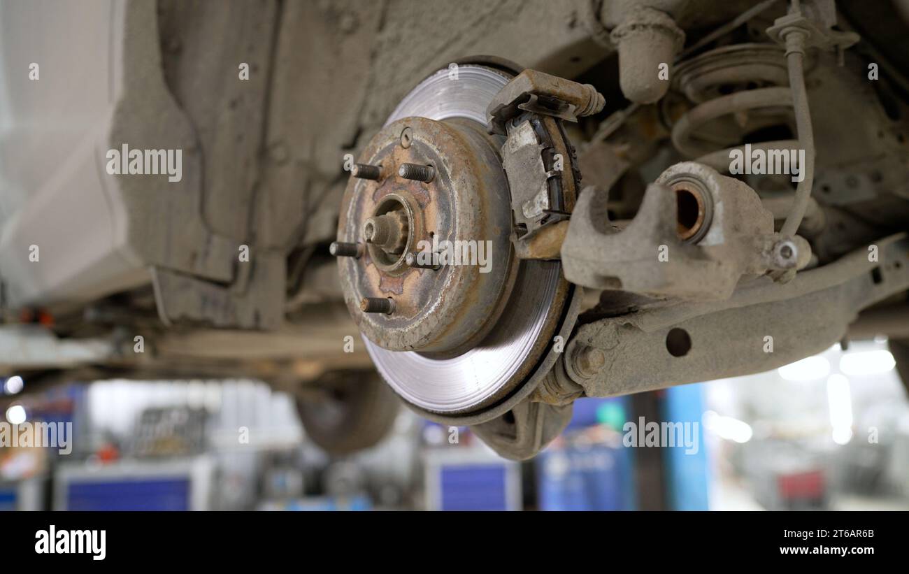 A modern car in a car service on a lift with a wheel removed. Elements ...