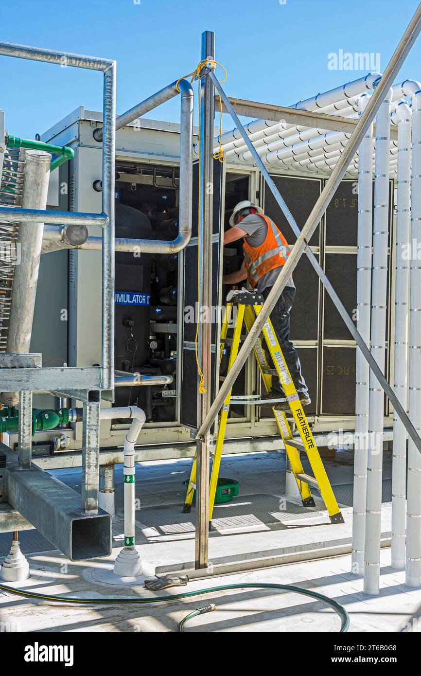 A worker working in the compressor panel of a CO2 cold-storage ...
