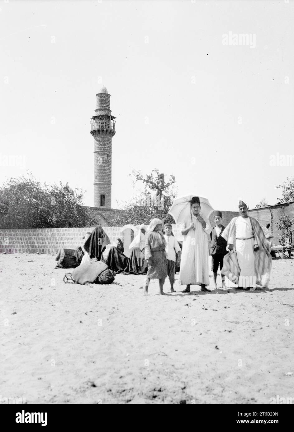 Group of Muslims with minaret in background, Nabi Rubin, Mandatory ...
