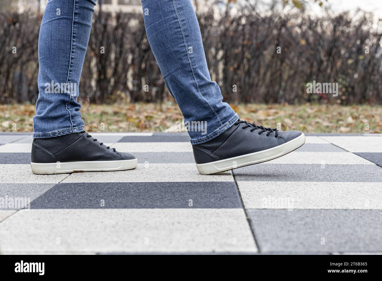 a man walks along a stone tile path. foot steps on stone tiles Stock ...
