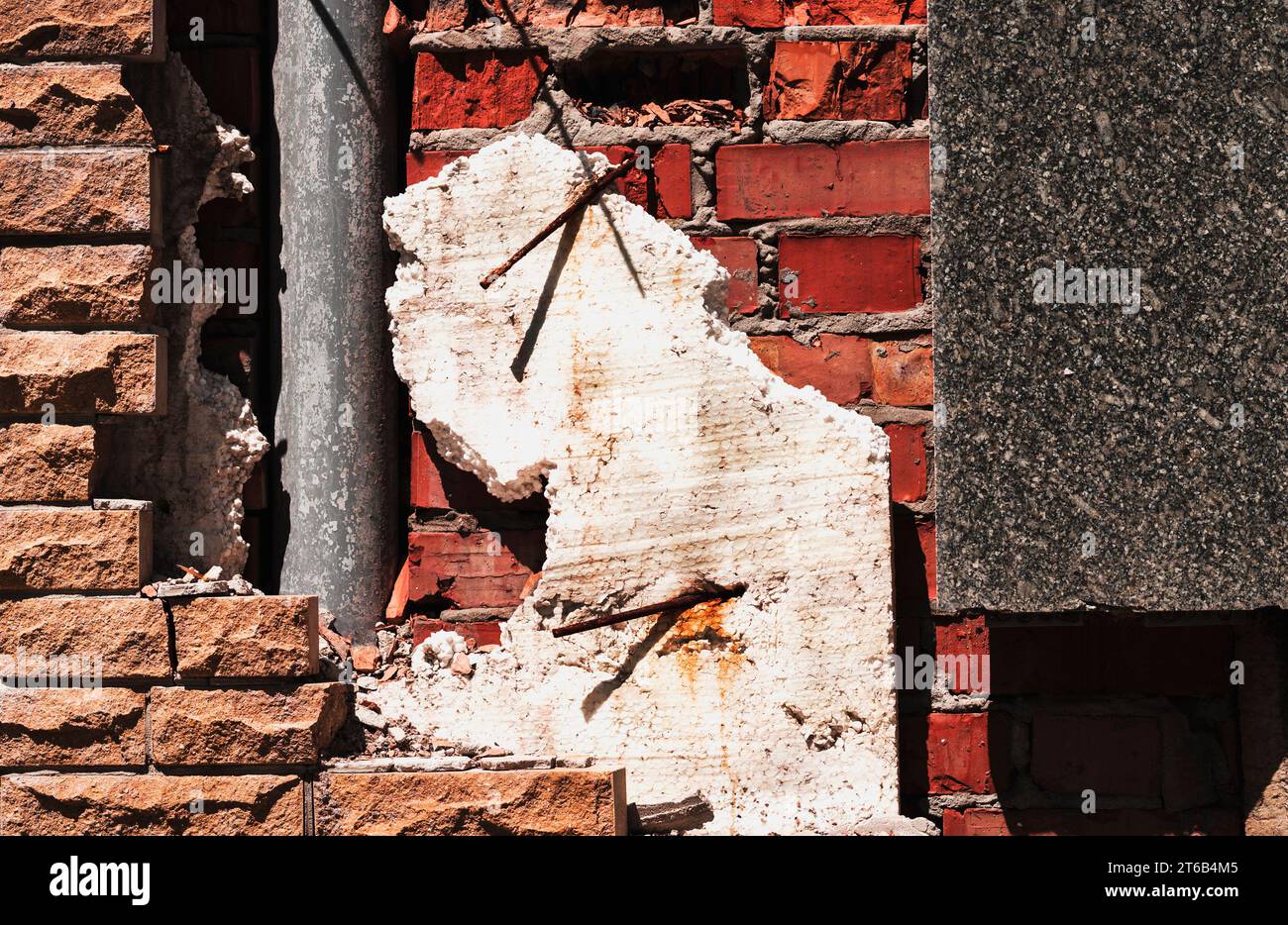 destroyed, broken wall. On the site of a wall it is visible a red brick ...