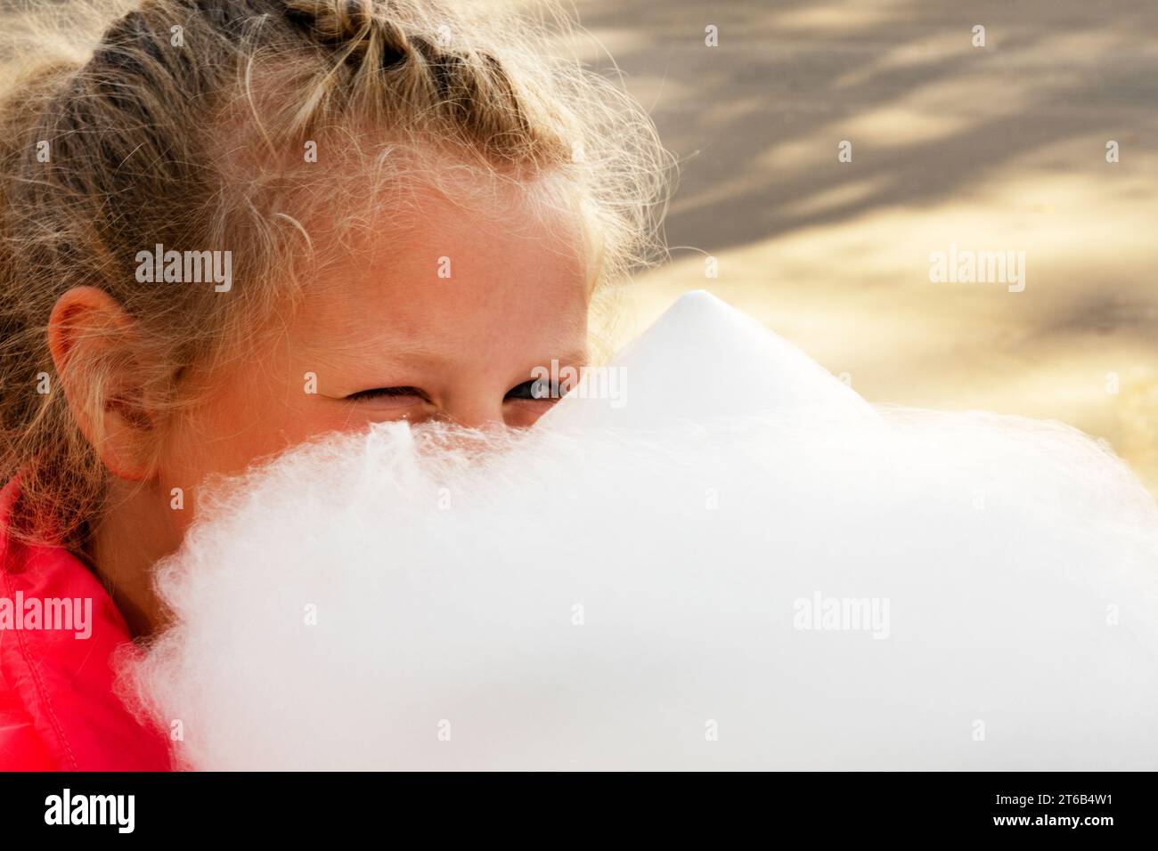 The girl holds huge cotton candy in hand. Delicacy for children Stock ...