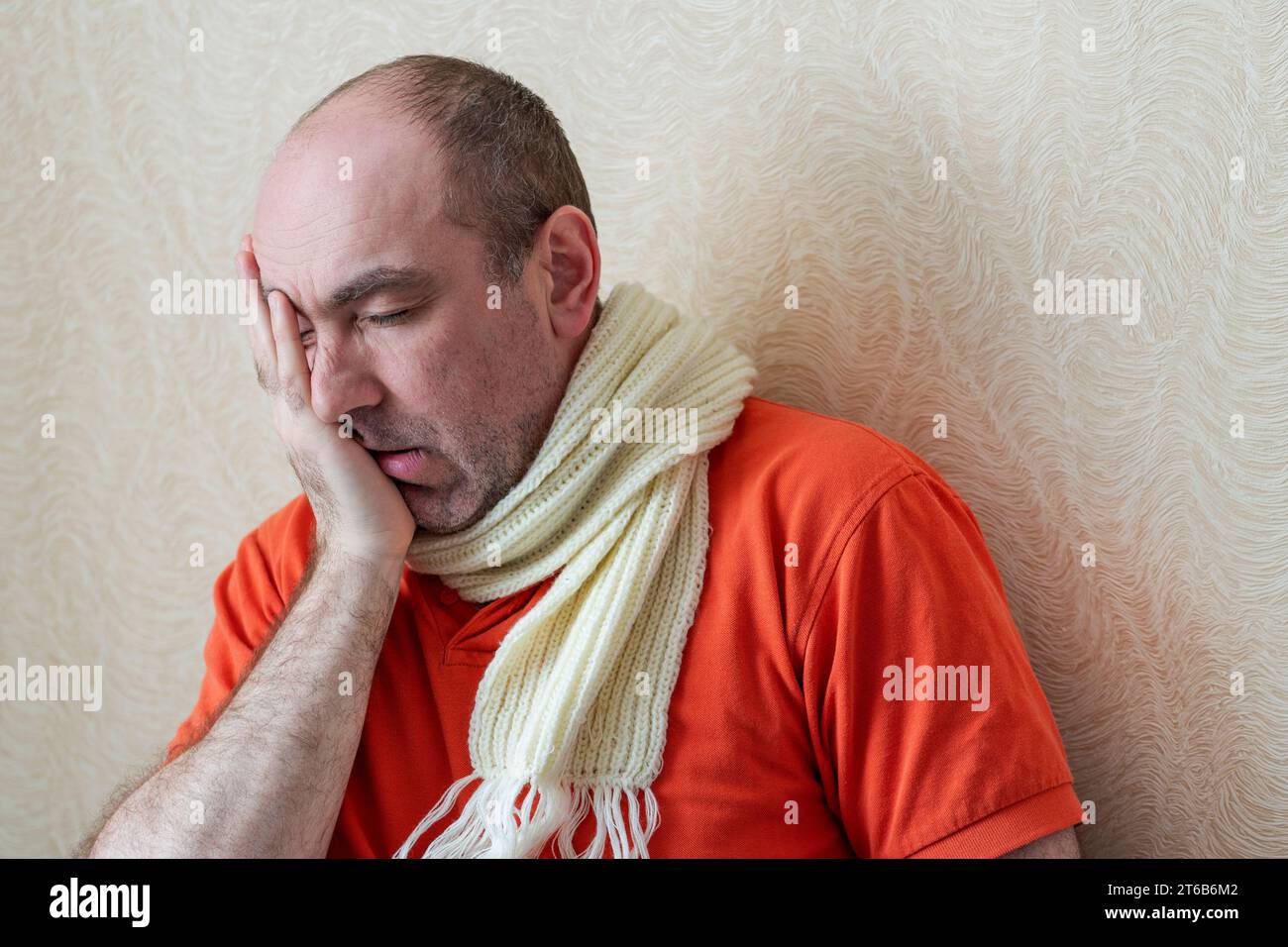 A sick man holds his hand over his head. The patient has a headache ...