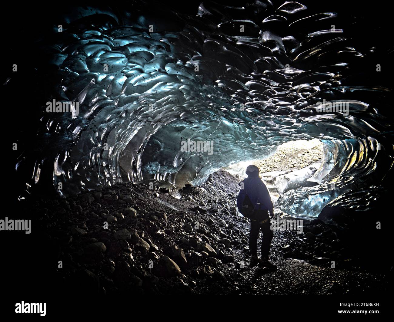 man exploring an ice cave in Iceland Stock Photo - Alamy