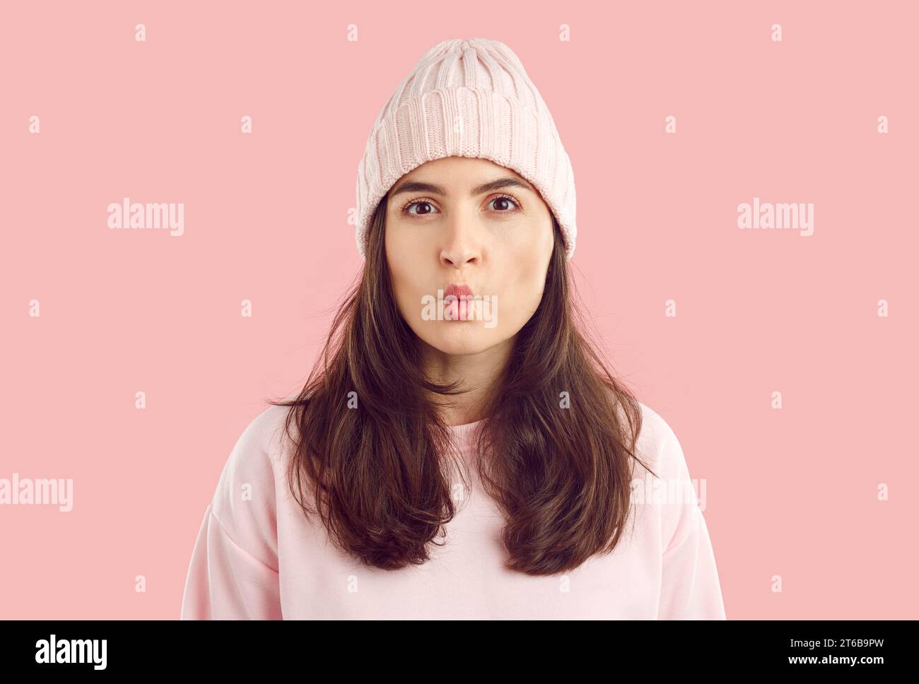Portrait of funny young fashion model in pastel pink winter hat ...