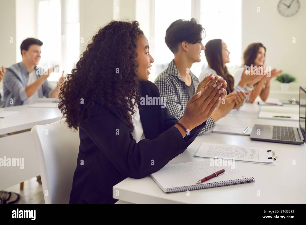 Group of a happy young diverse students applauding to lecturer during a ...