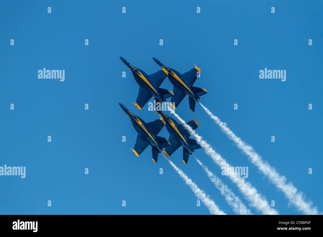 Four airplanes flying in formation while emitting trails of white smoke ...