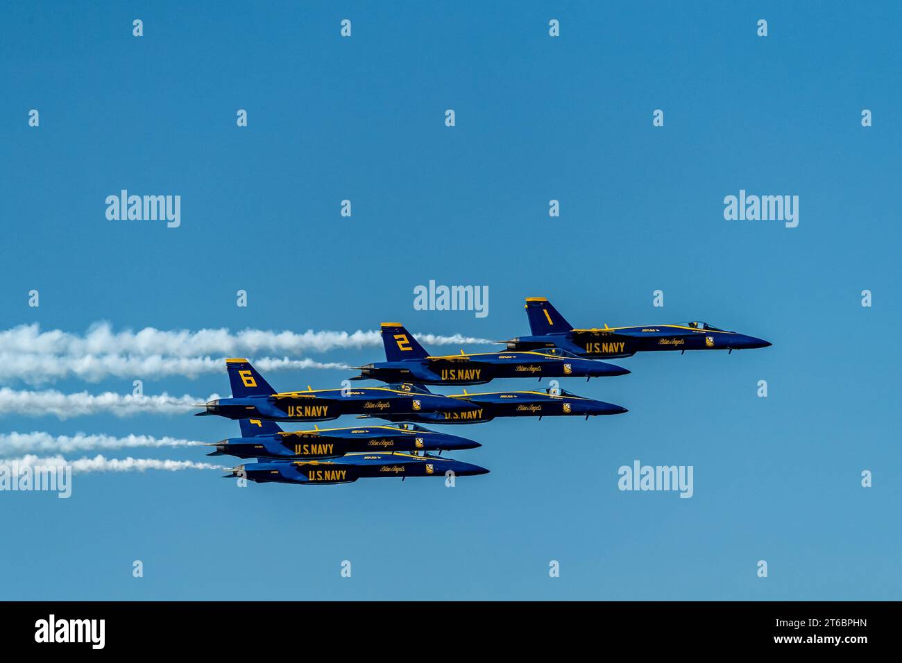 A formation of five fighter jets flying in unison against a clear blue ...