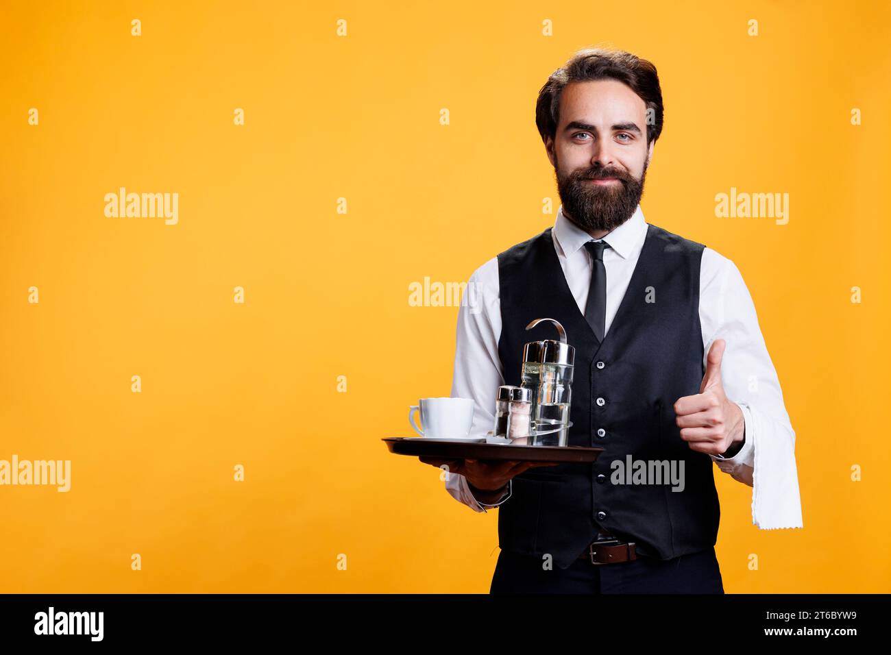 Happy waiter does thumbs up sign while he holds platter with coffee and ...