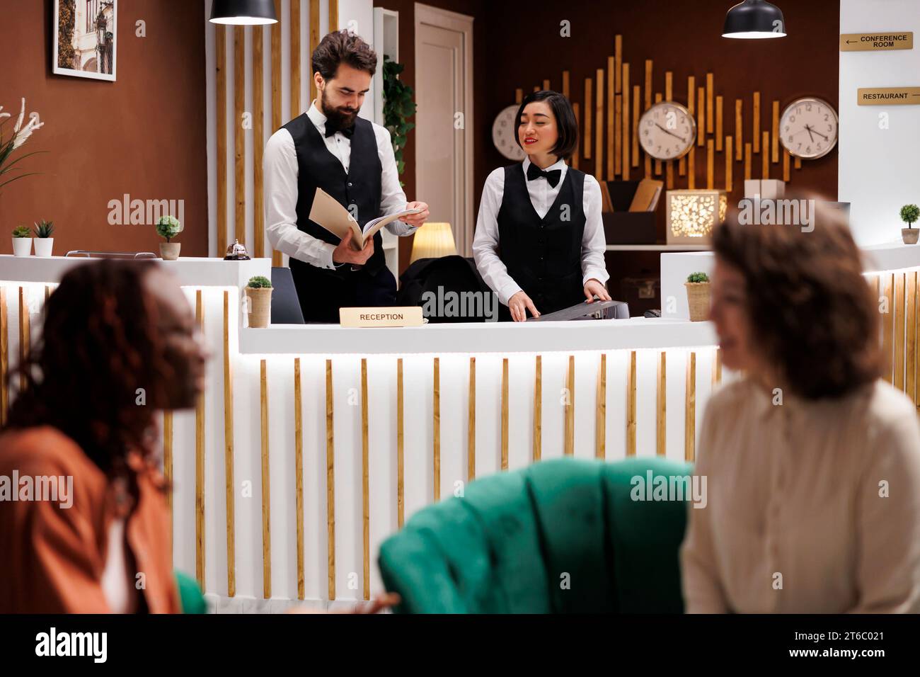 Diverse reception staff working at hotel, preparing accommodation and ...