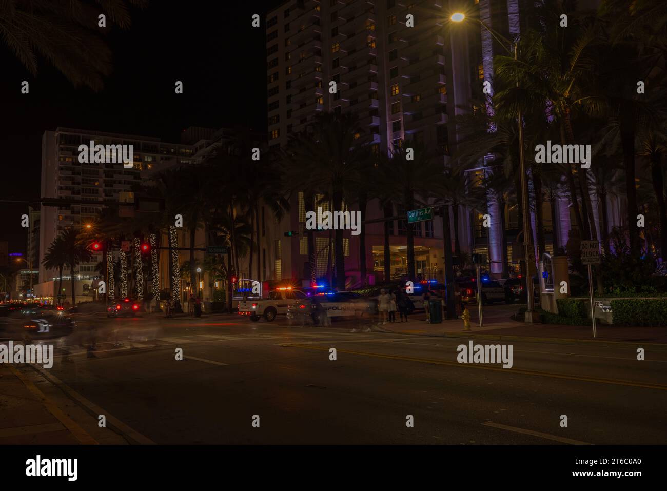 Nighttime view of Collins Avenue with several police cars, their ...