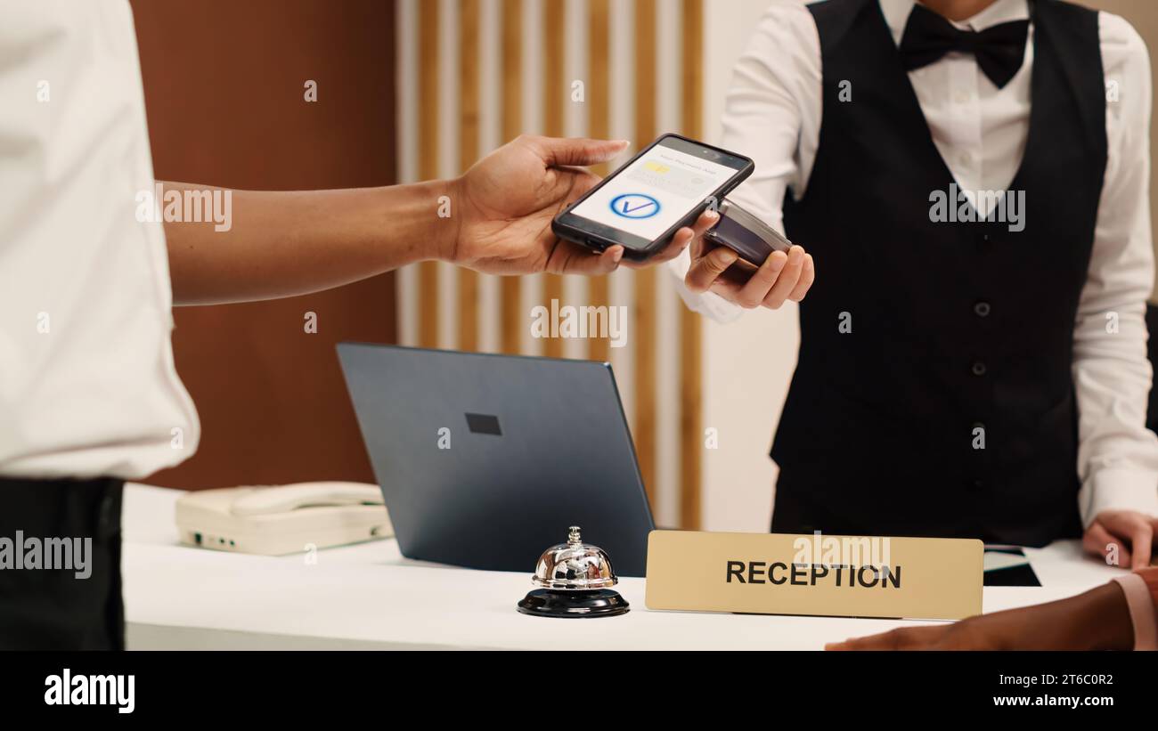 Receptionist using POS payment terminal to validate card purchase of ...