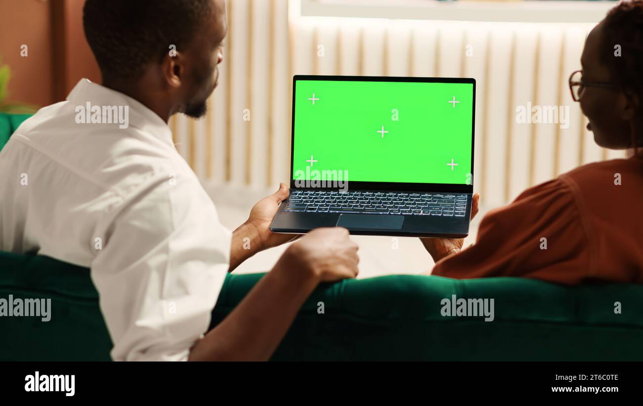 Bored tourists watching video on laptop chroma key green screen mock up ...