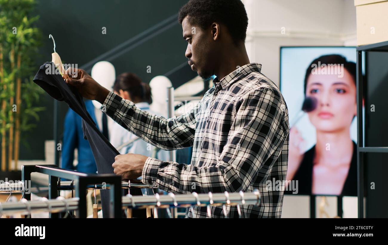 Stylish customer shopping for casual wear, analyzing merchandise fabric ...