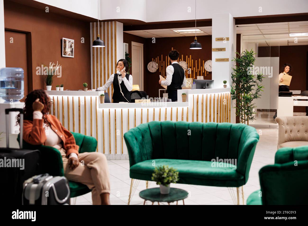 Asian employee answering booking call, using landline phone to write ...