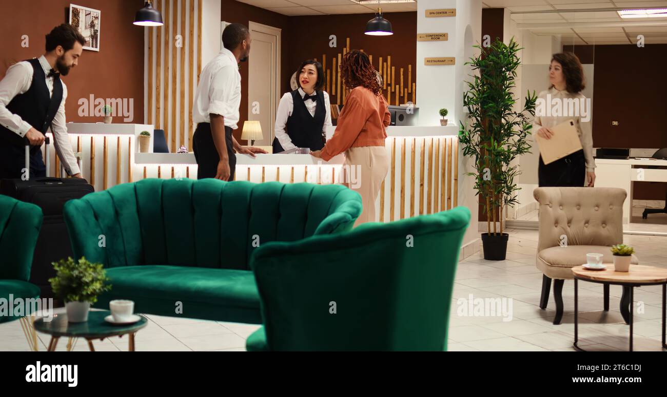 Friendly smiling concierge personnel welcoming guests in hotel lobby ...