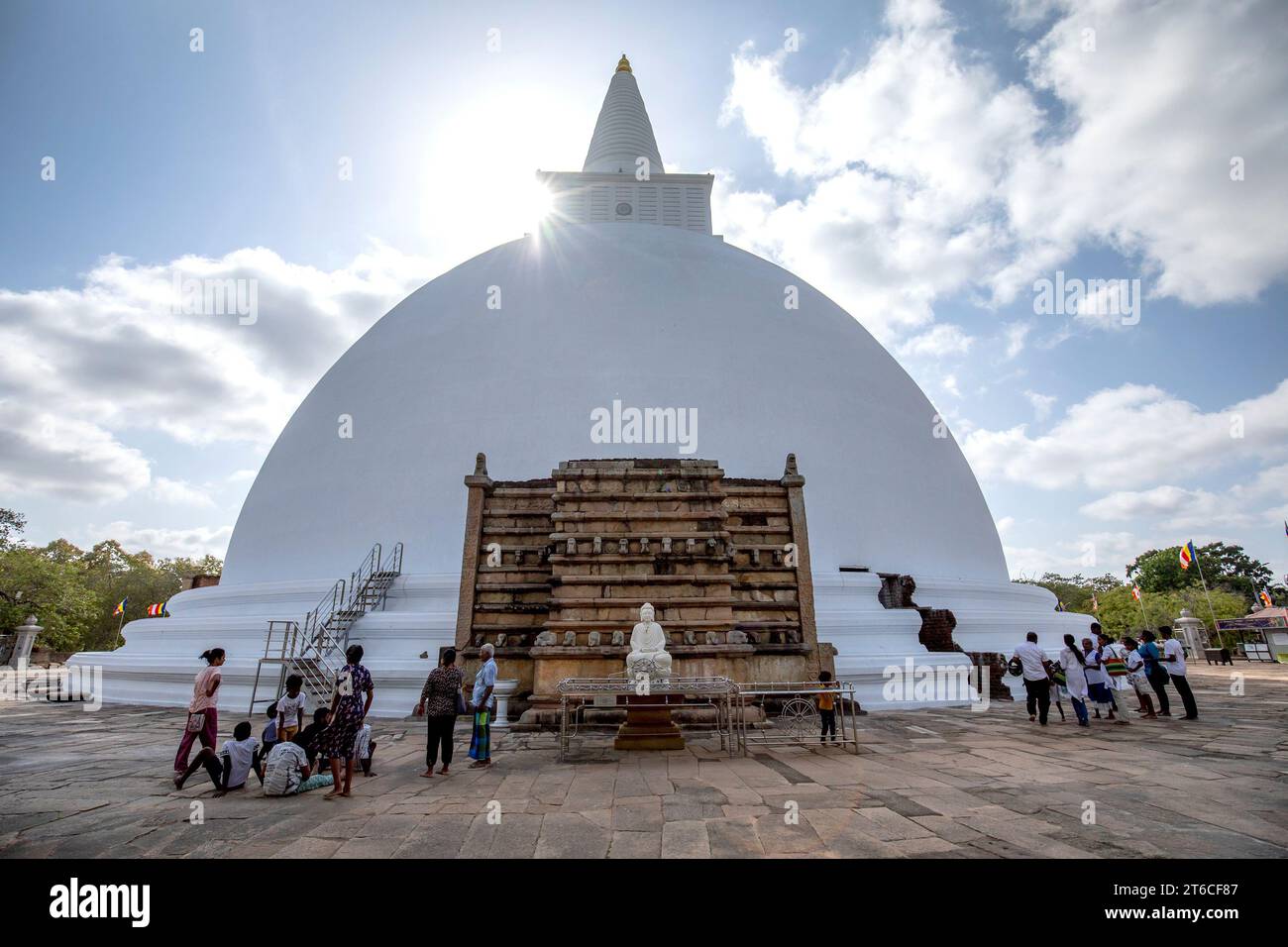 Visitors rest in the shade of the Mirisavetiya which is the first stupa ...