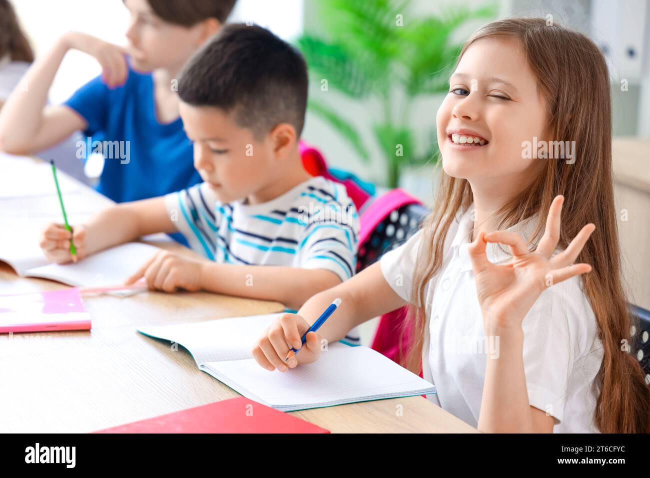 Little schoolgirl showing OK during lesson in classroom Stock Photo - Alamy
